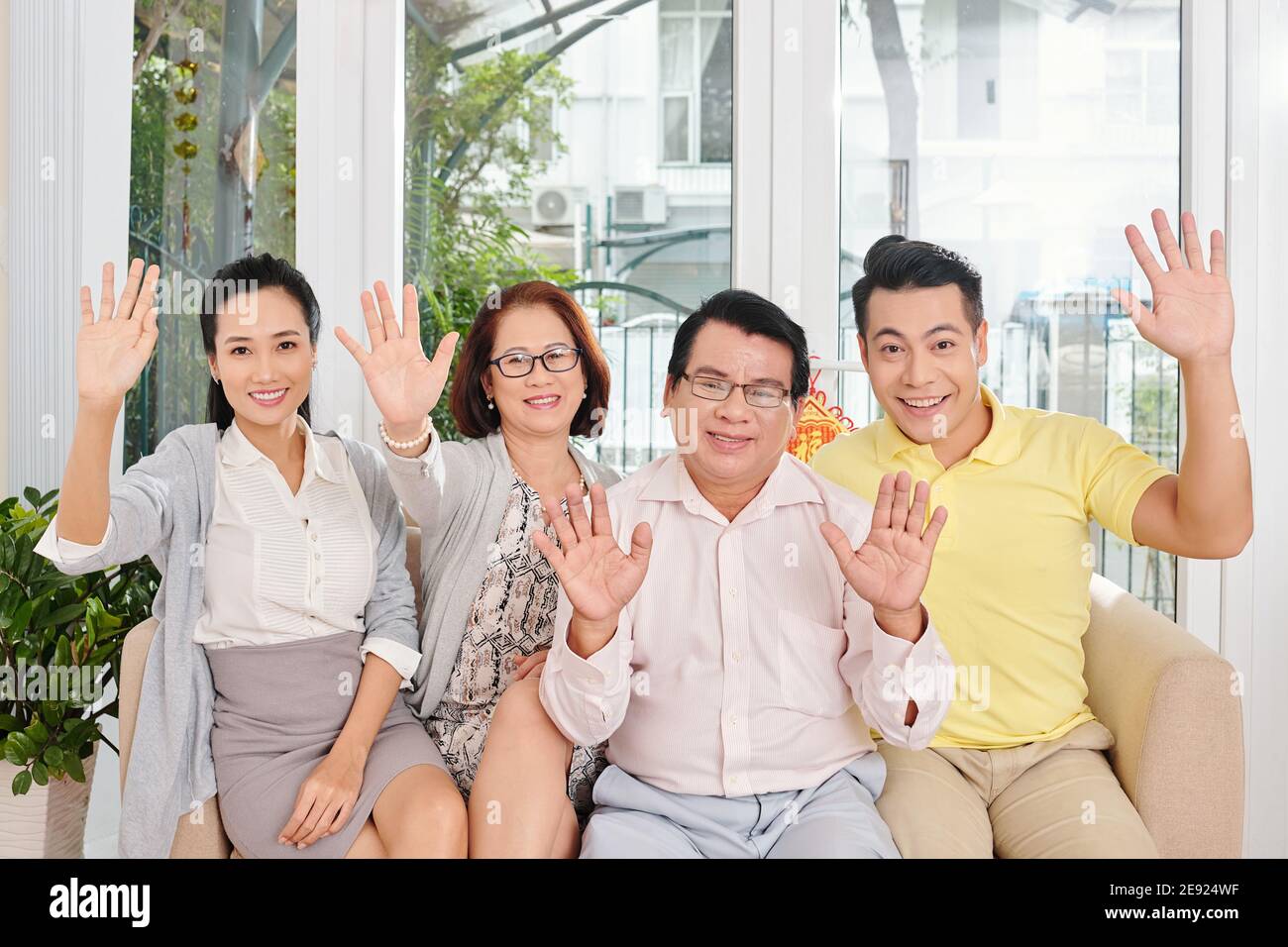 Happy family waving with hands Stock Photo - Alamy