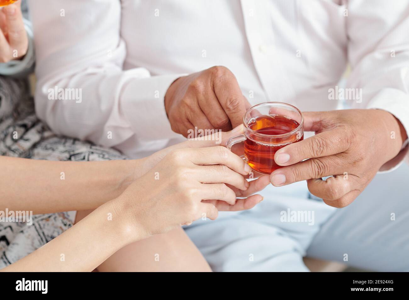 Daughter giving tea to father Stock Photo - Alamy