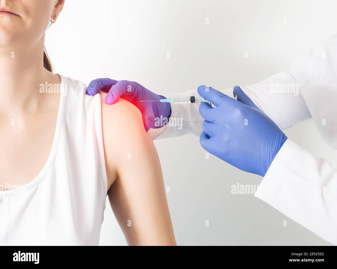 The doctor makes a girl patient an injection blockade in the shoulder ...