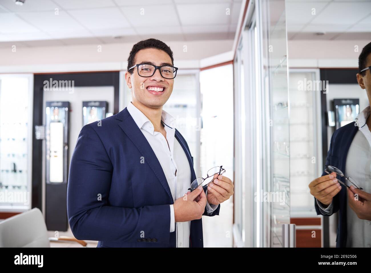 Smiling customer holding stylish spectacles in his hands Stock Photo ...