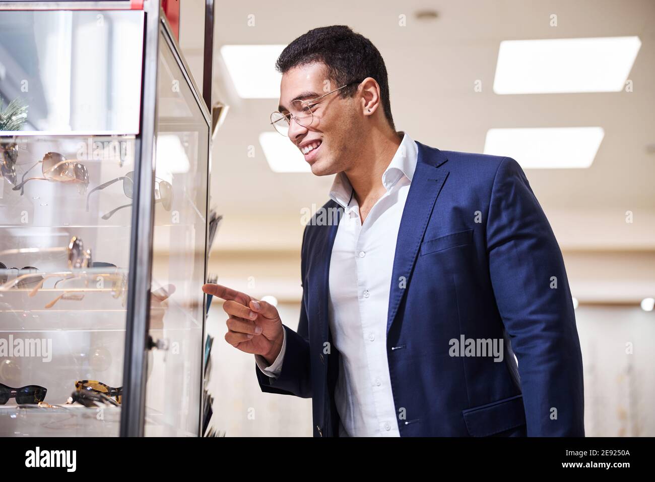 Pleased male customer staring at stylish sunglasses Stock Photo - Alamy