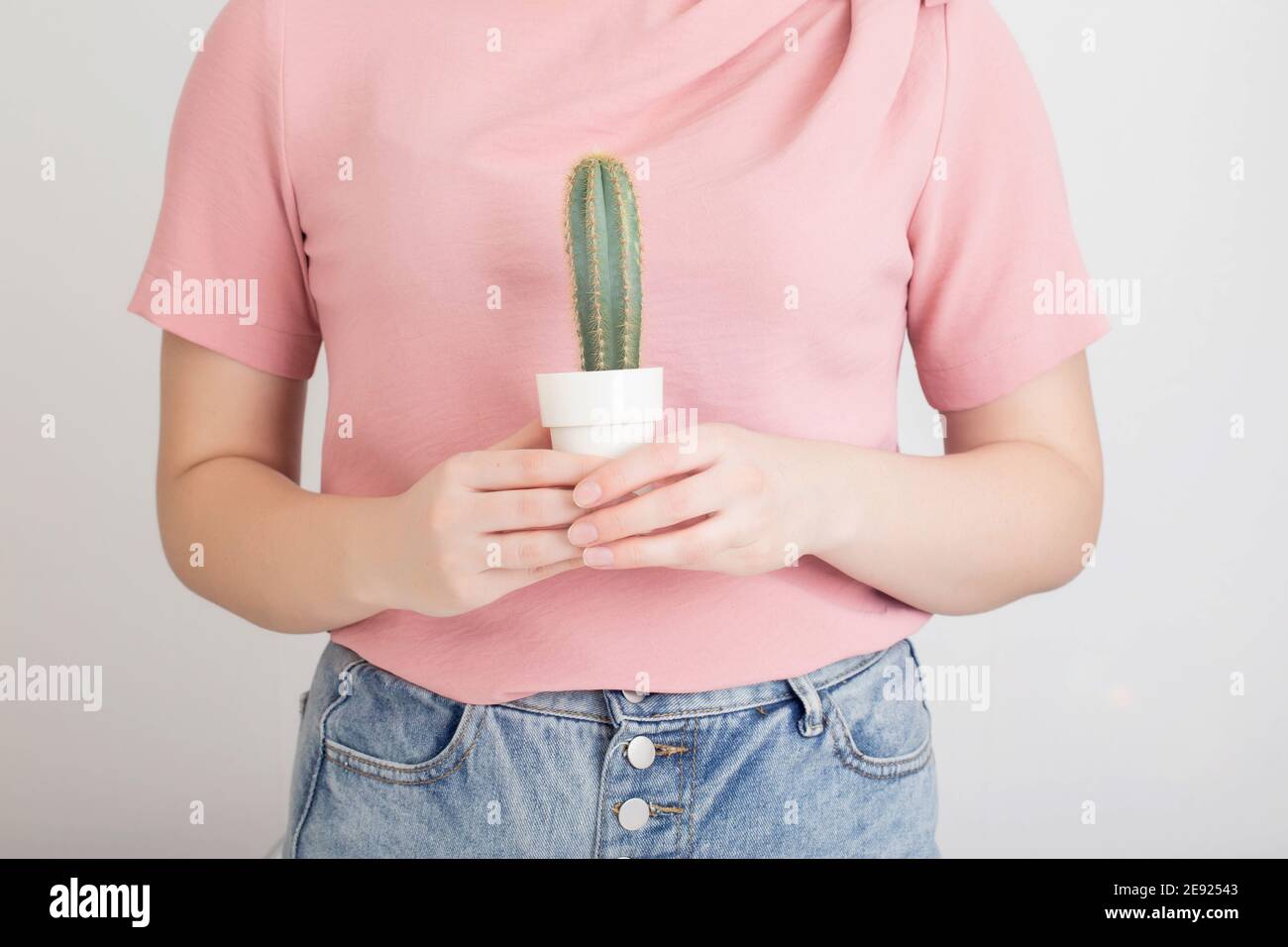 Girl holding a cactus on the background of the stomach. Stitching ...