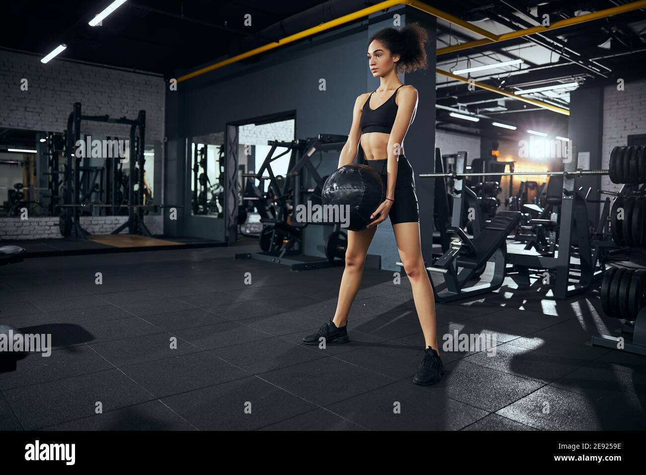 Concentrated brunette woman keeping her back straight Stock Photo - Alamy