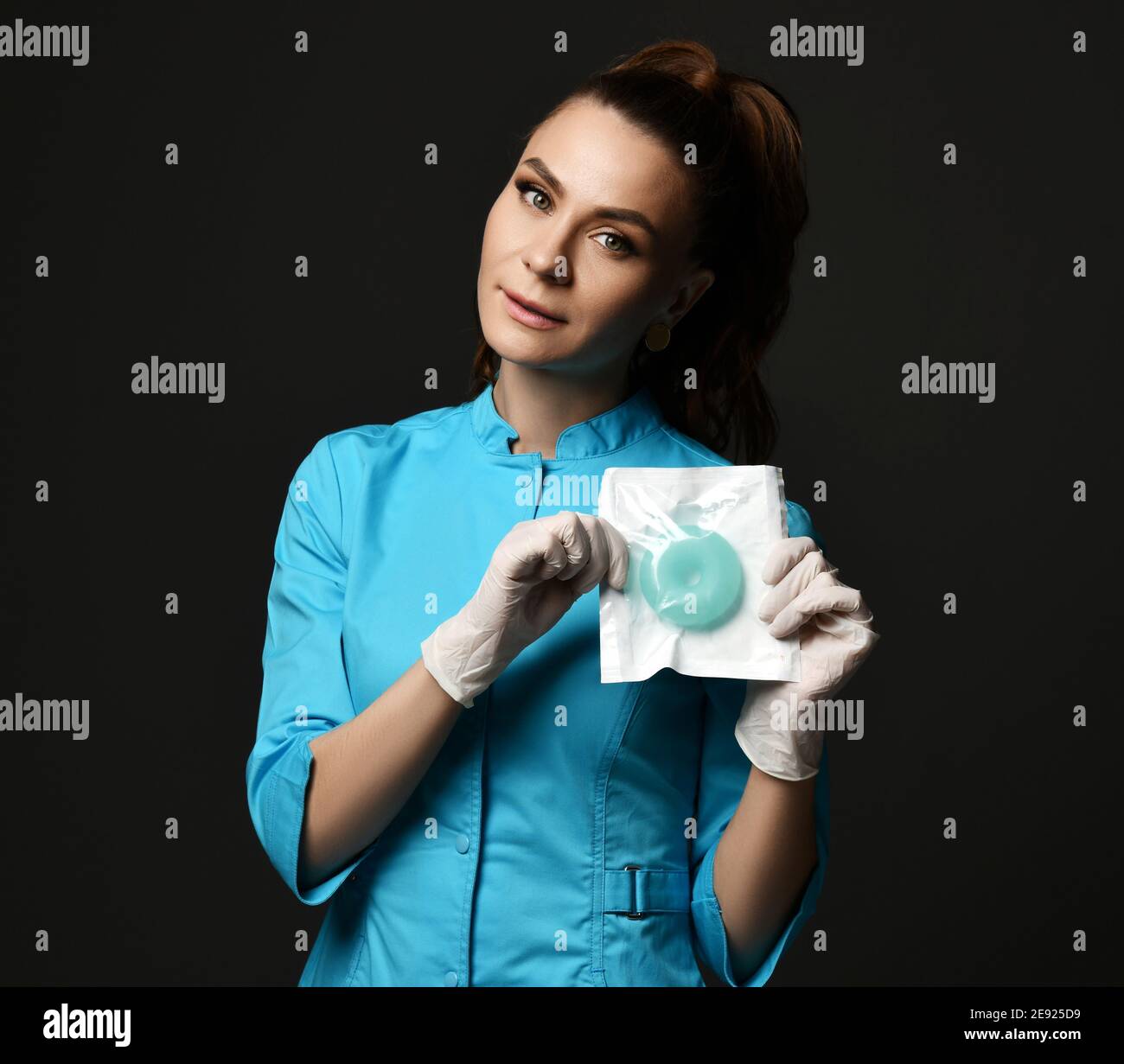 Young woman doctor nurse in blue uniform and protective latex gloves ...