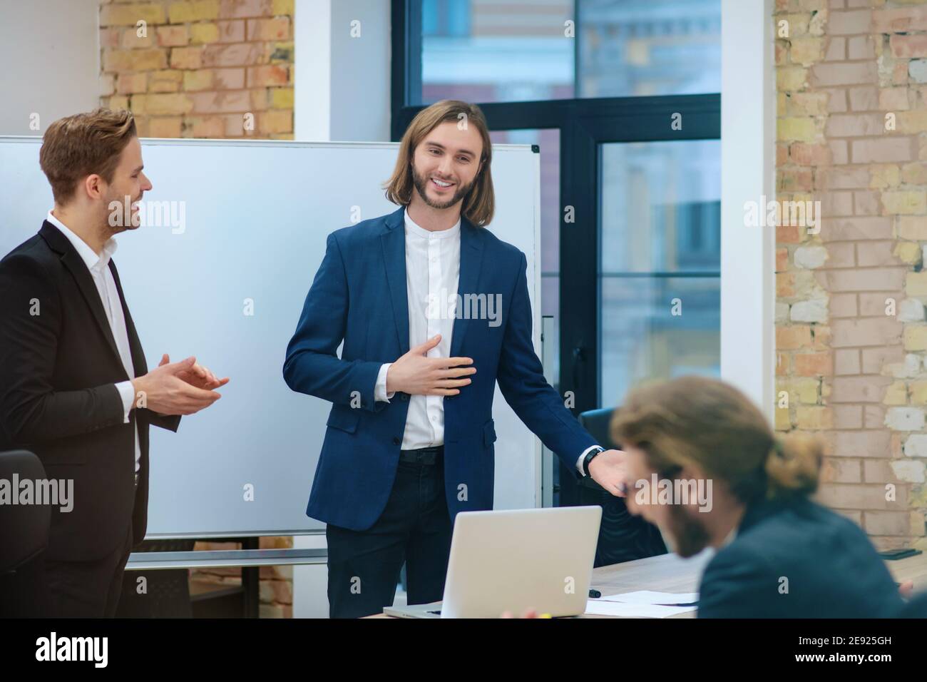 Contented man in suit and colleague clapping hands Stock Photo - Alamy