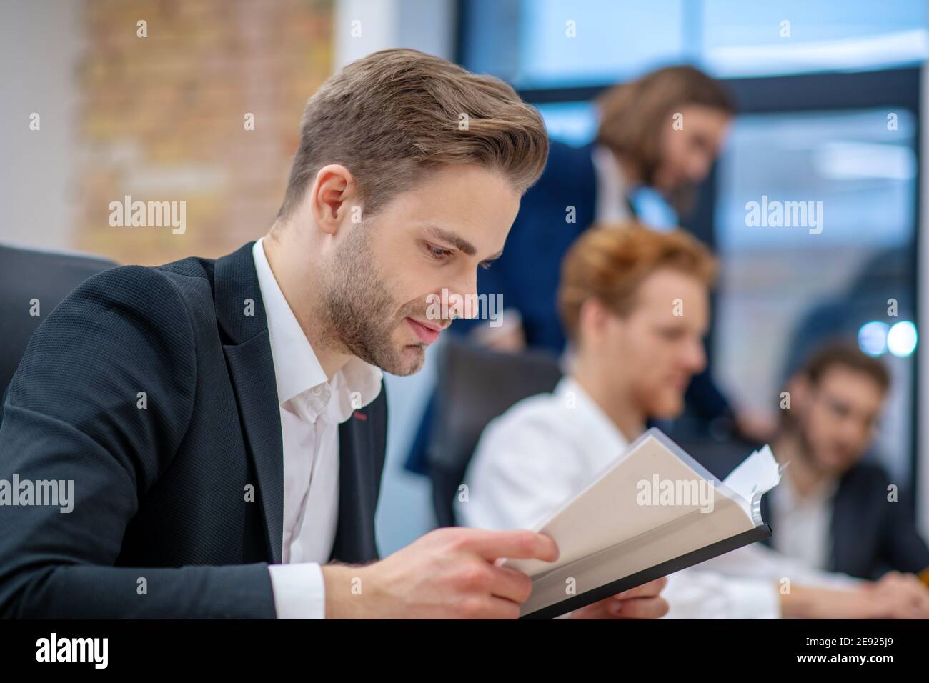 Attentive man in suit reading document Stock Photo - Alamy