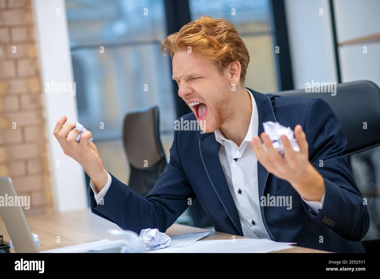 Angry screaming man sitting at workplace Stock Photo - Alamy