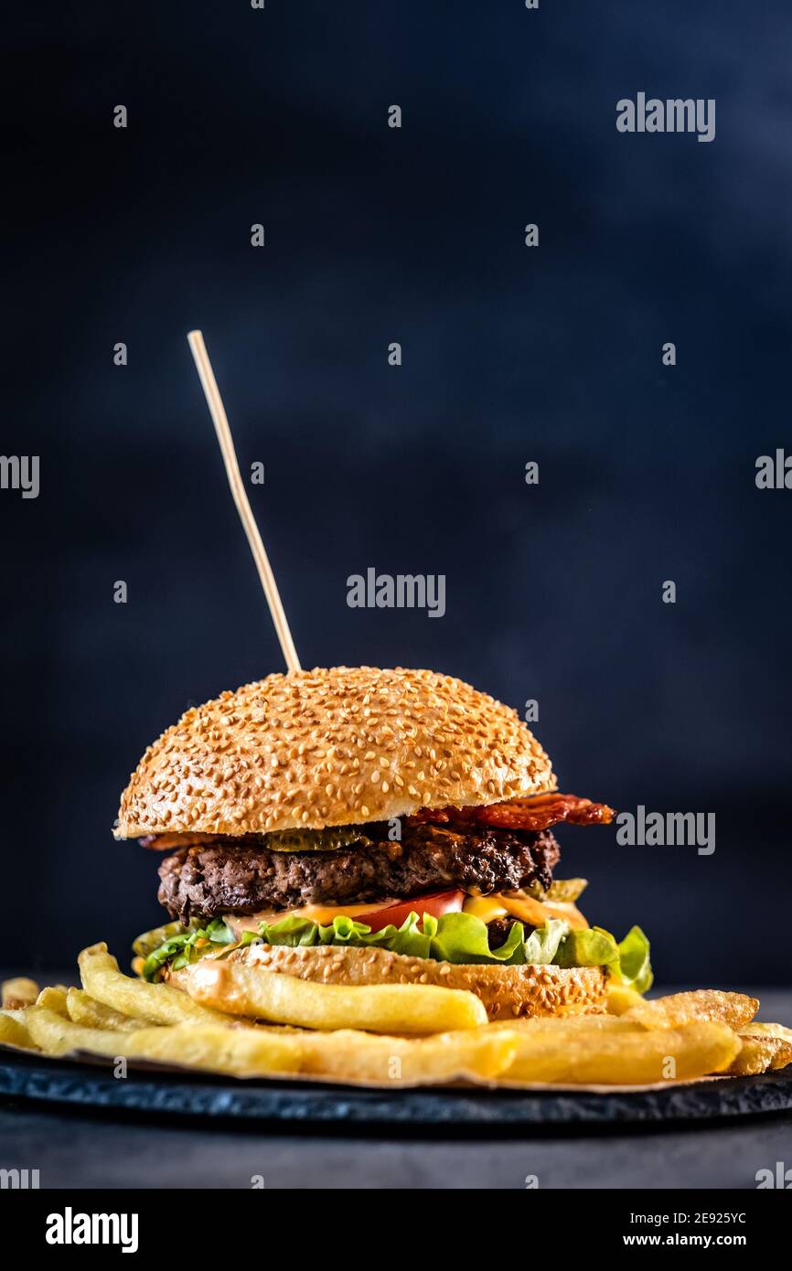 Juicy burger on stone plate with french fries Stock Photo - Alamy