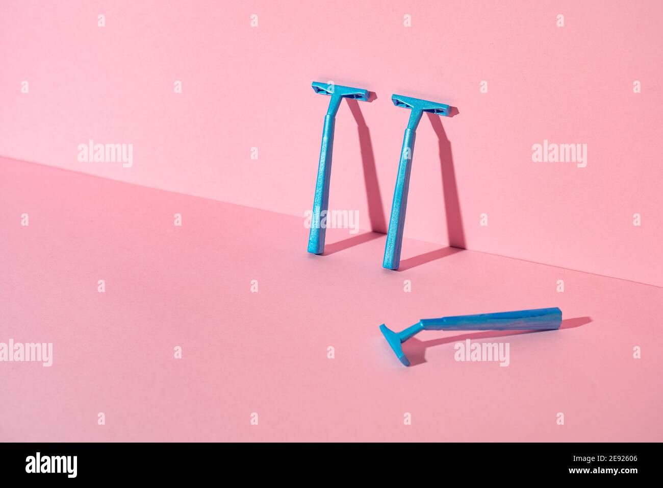 Blue disposable razors on pink paper background Stock Photo - Alamy