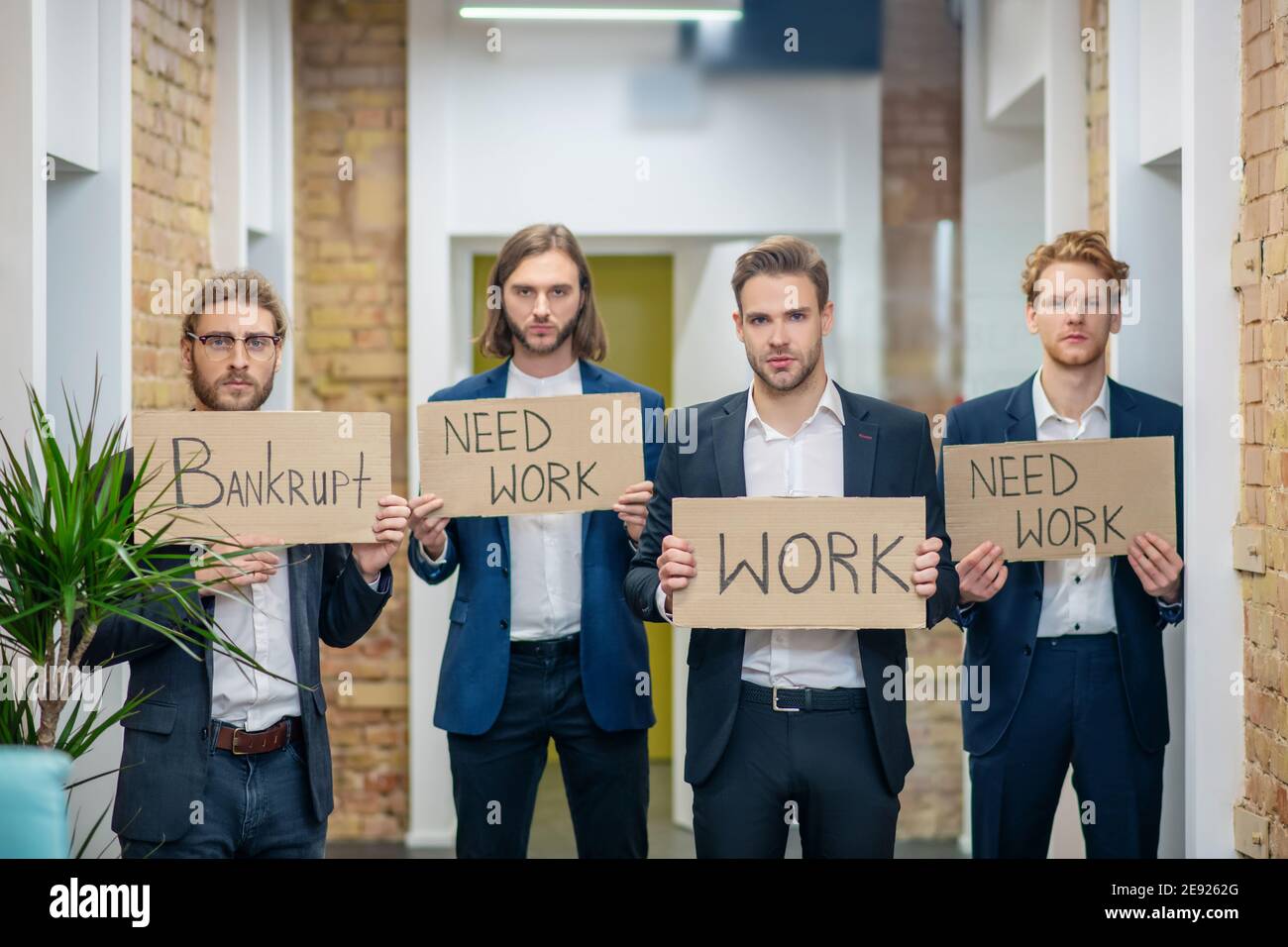 Four sad men with placards in their hands Stock Photo - Alamy
