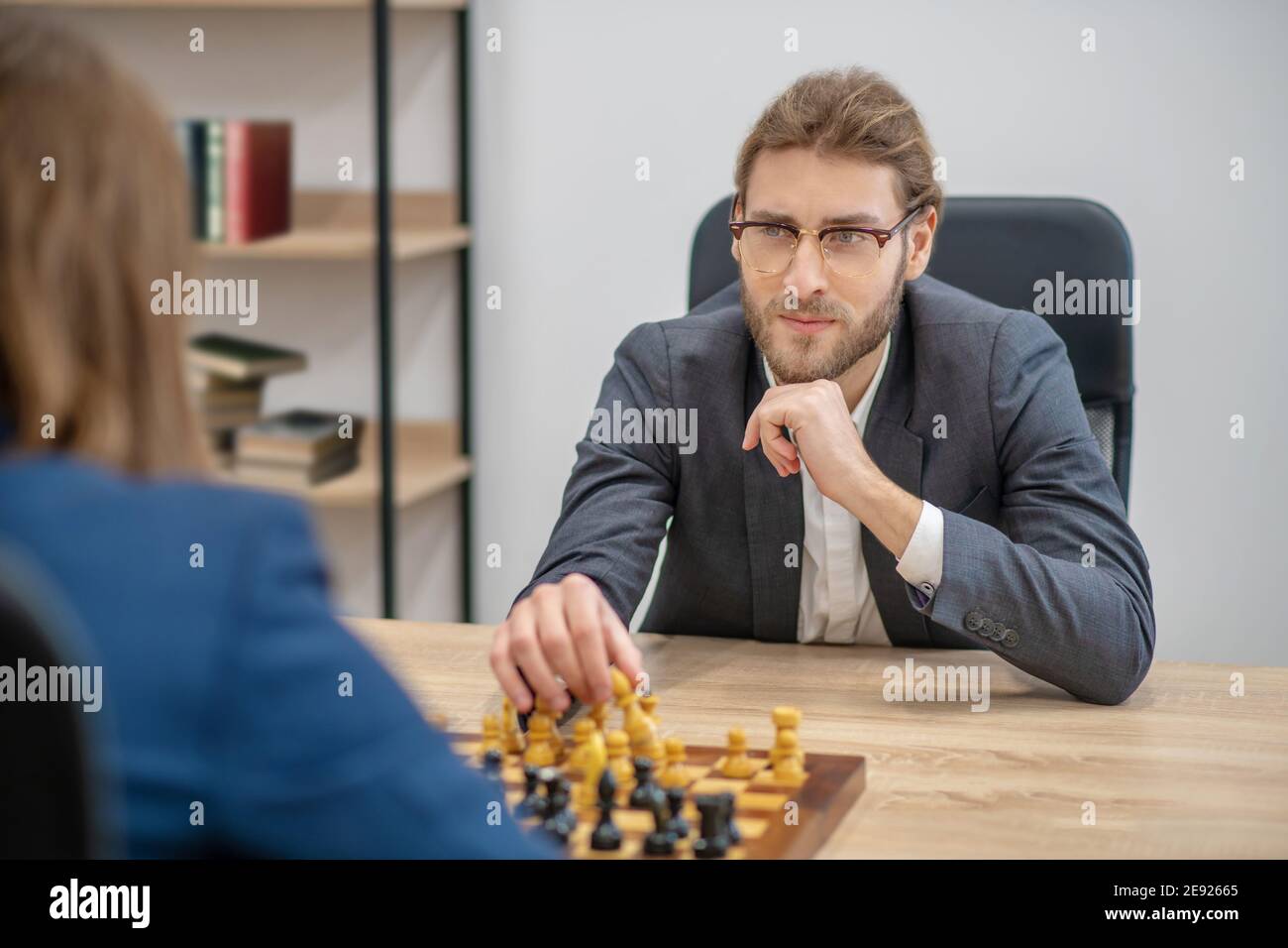 Man in glasses with chess piece in hand Stock Photo - Alamy
