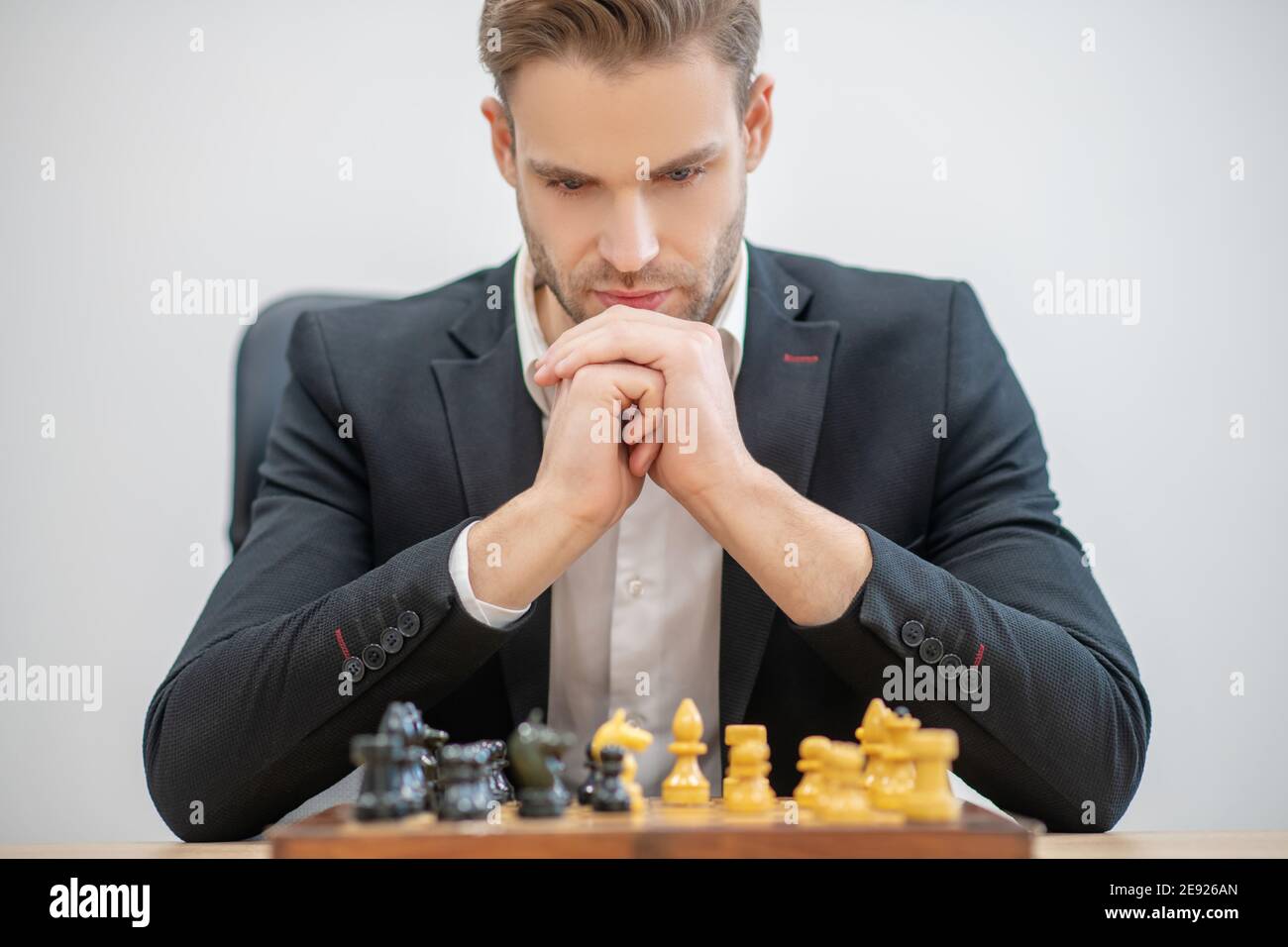 Serious involved man in front of chessboard Stock Photo - Alamy