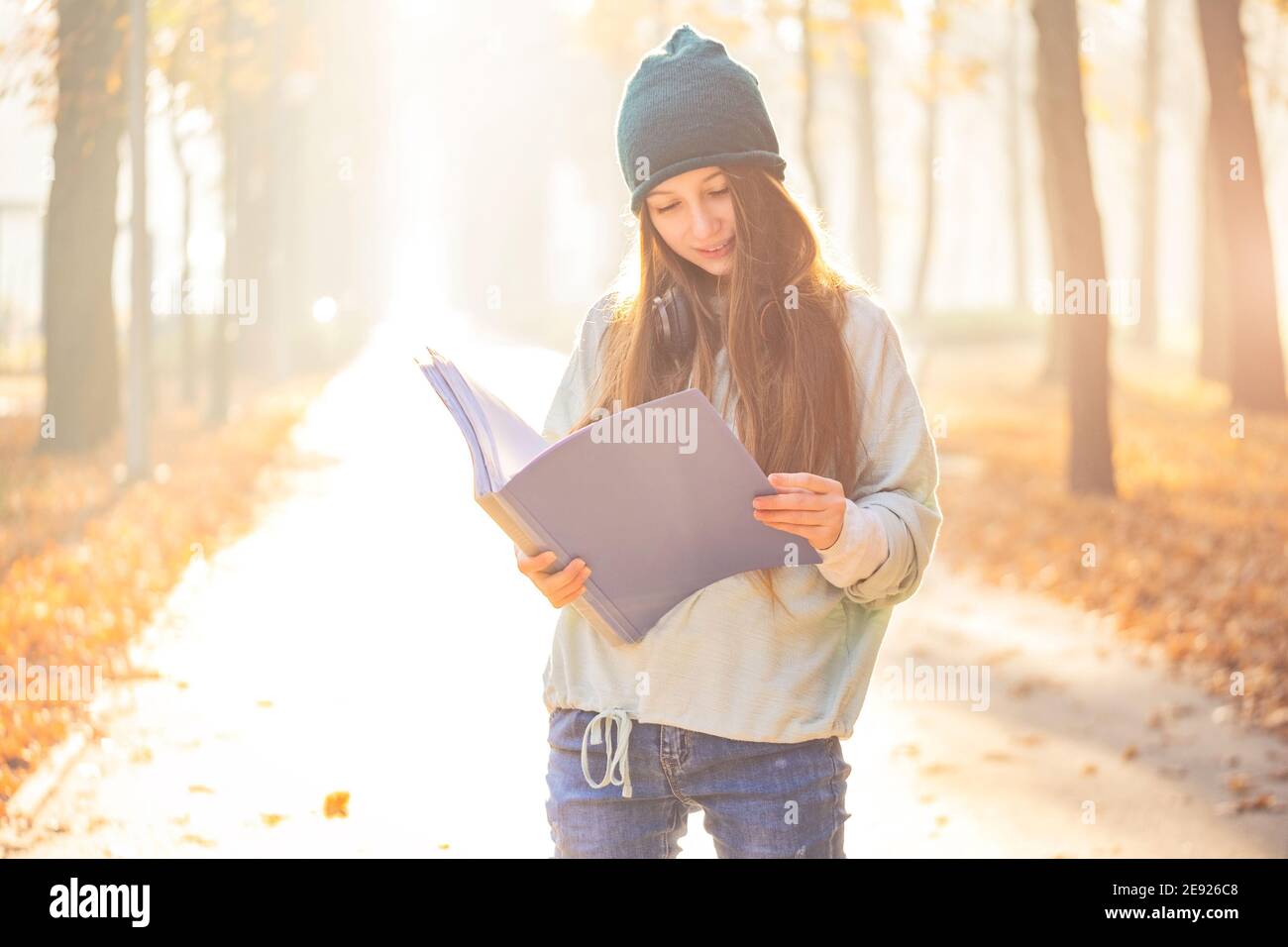 Cute teenage girl reading notes in park Stock Photo - Alamy