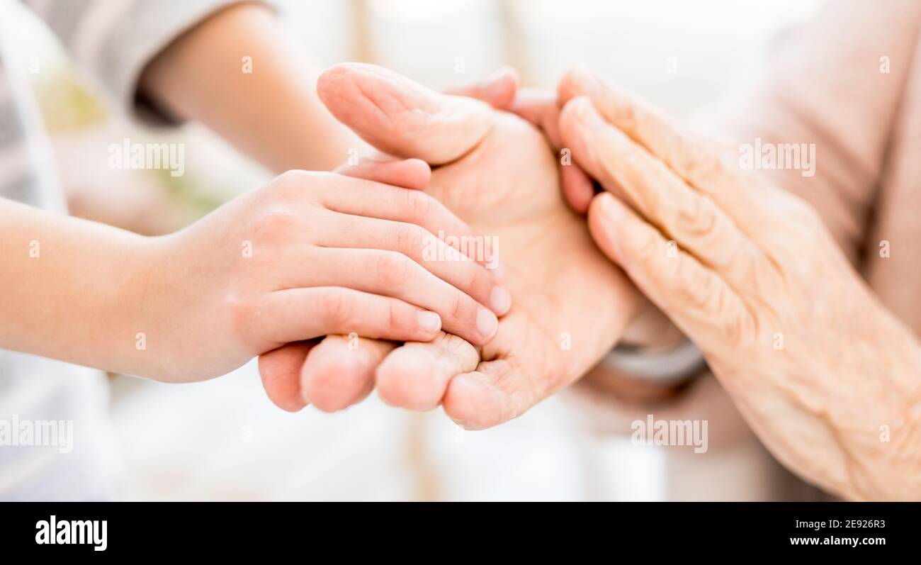 Interweaving of young and old hands on light background Stock Photo - Alamy