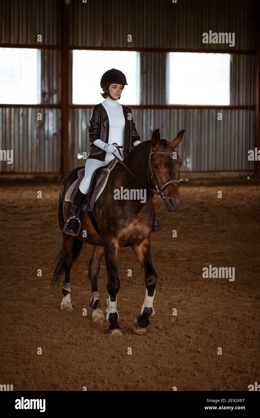 Young woman is engaged in equestrian sports, training on horseback ...