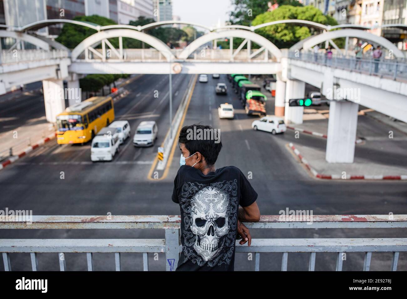A man wearing a face mask stands in downtown Yangon a day after the ...