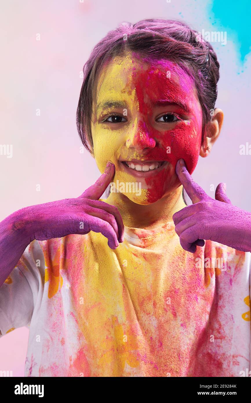 Portrait of a young girl smiling with gulal on her face Stock Photo - Alamy