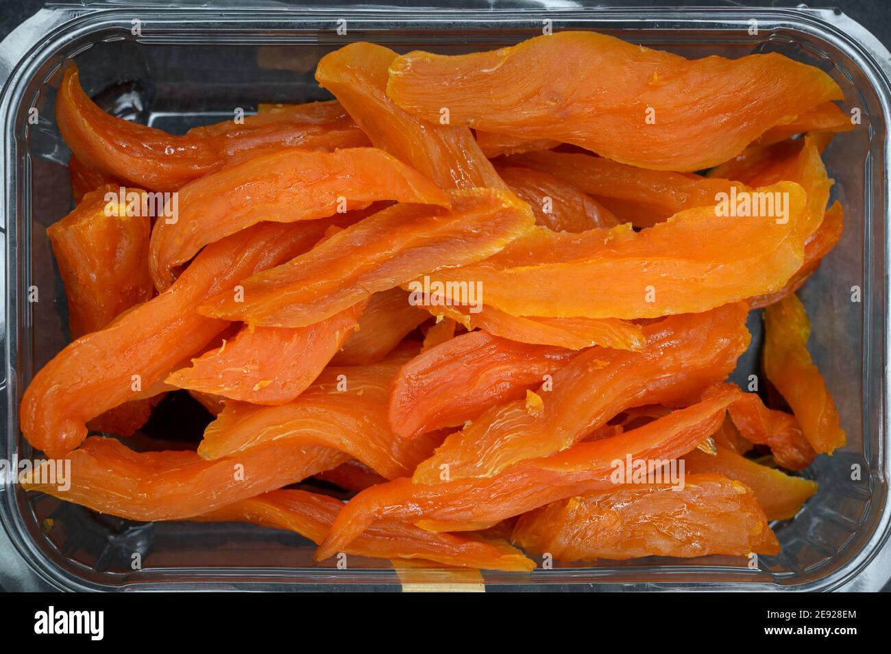 Dried mango on a in a plastic box on dark background. Selective focus ...