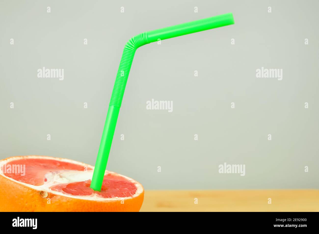 a green drinking straw in half a juicy grapefruit to enjoy a delicious ...