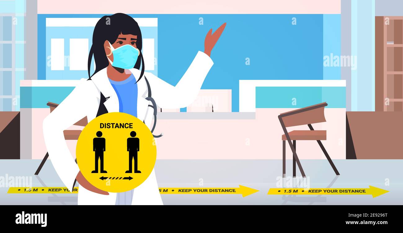 female doctor in mask holding yellow round sign for social distancing ...