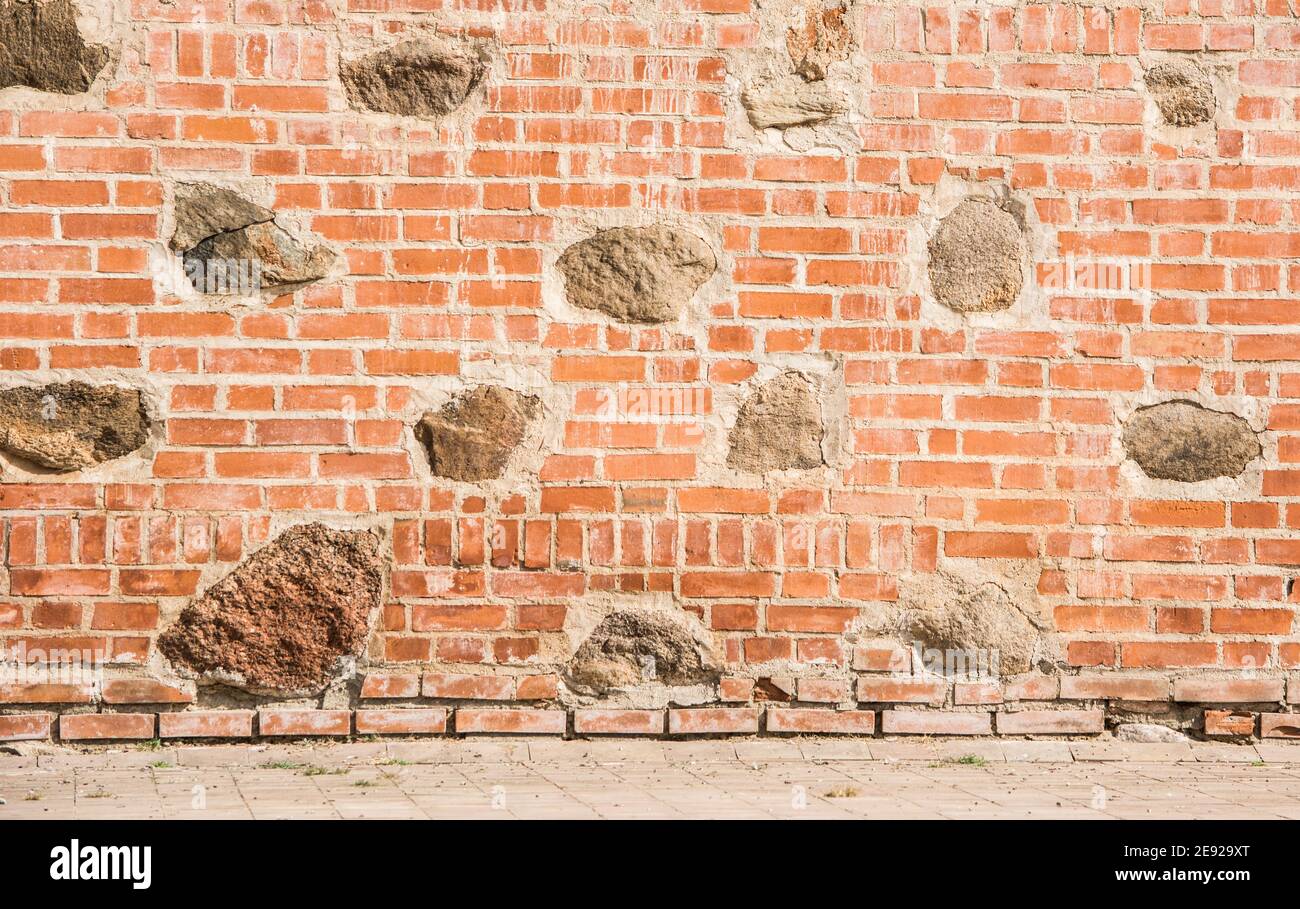 red brick wall with large stones embedded in it Stock Photo - Alamy
