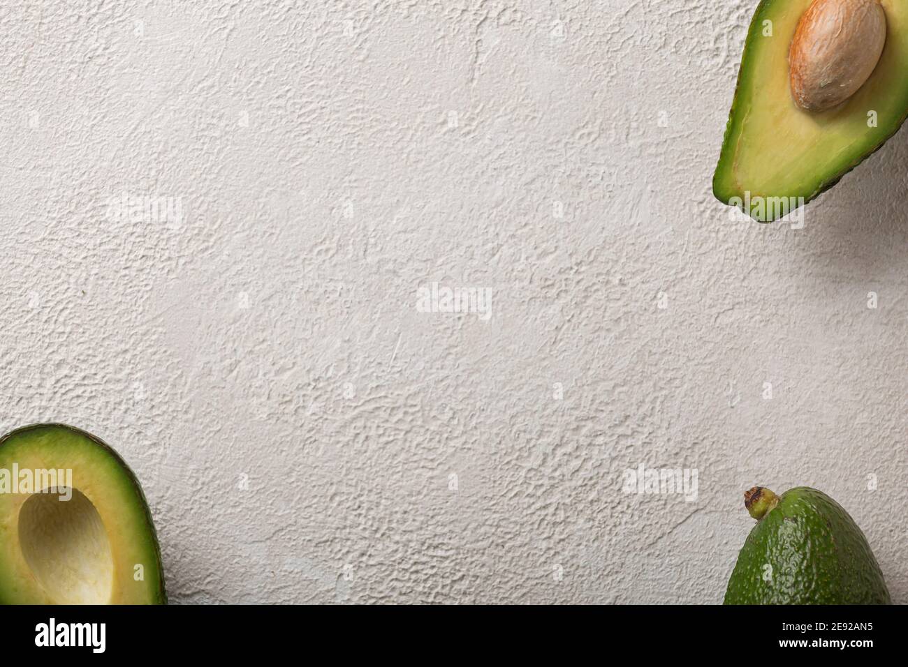 Avocado on light concrete background Stock Photo - Alamy