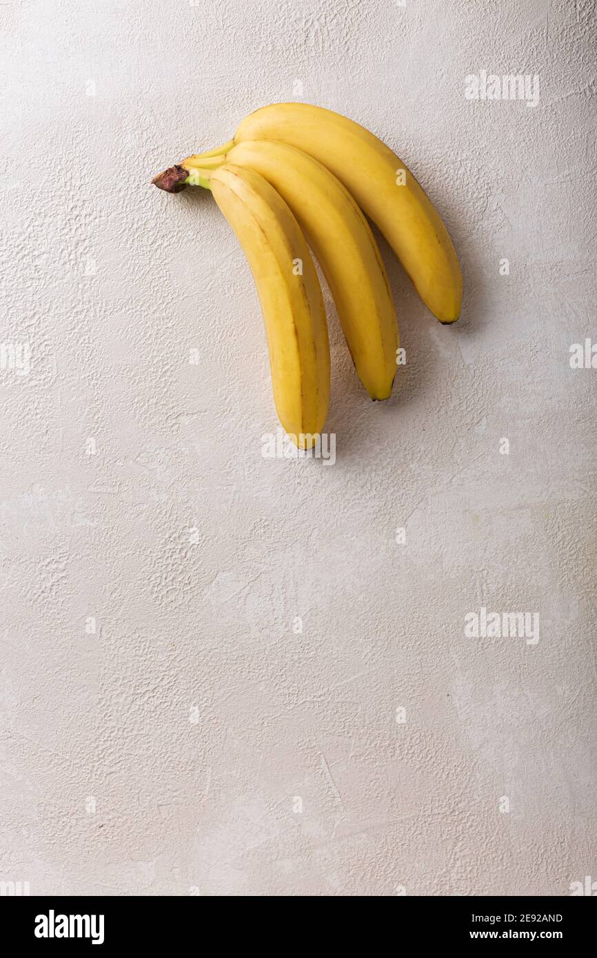 Branch of ripe bananas on light background Stock Photo - Alamy