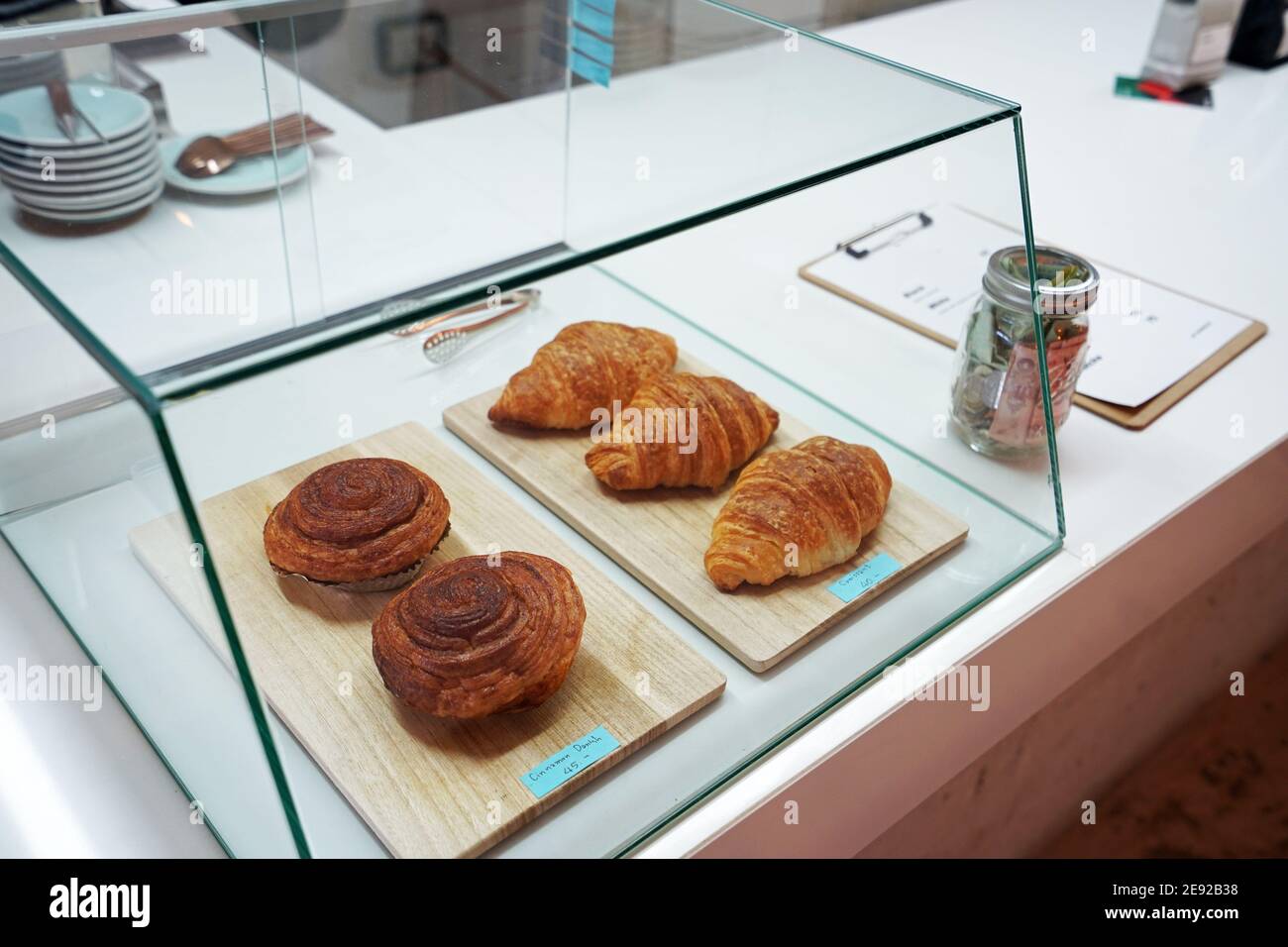 Butter plain croissants and cinnamon danish rolls in bakery display ...