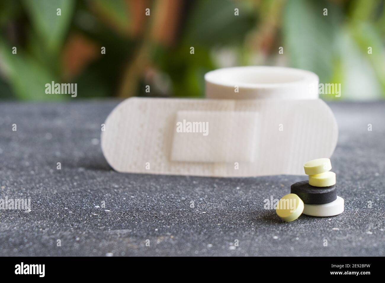 Stack of tablet pills with a band-aid background Stock Photo - Alamy