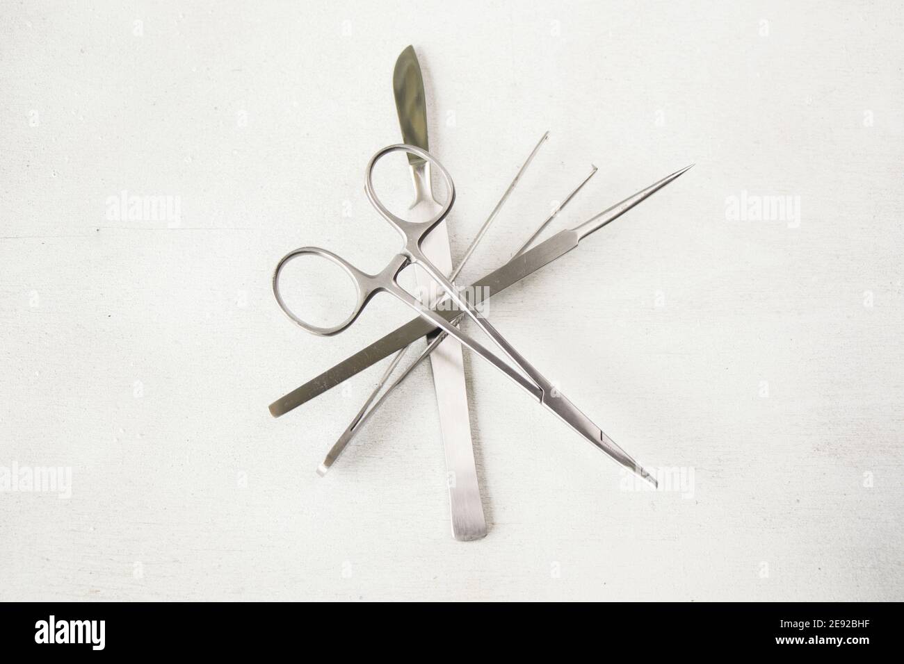 Top view of stainless steel dissecting kits stacked on white background ...