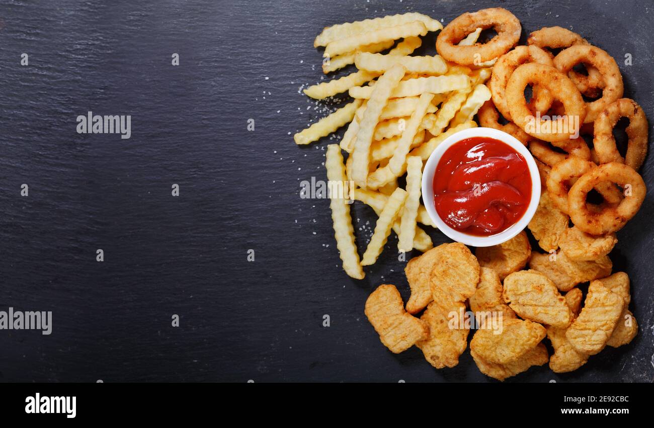 fast food products: onion rings, french fries and chicken nuggets on ...