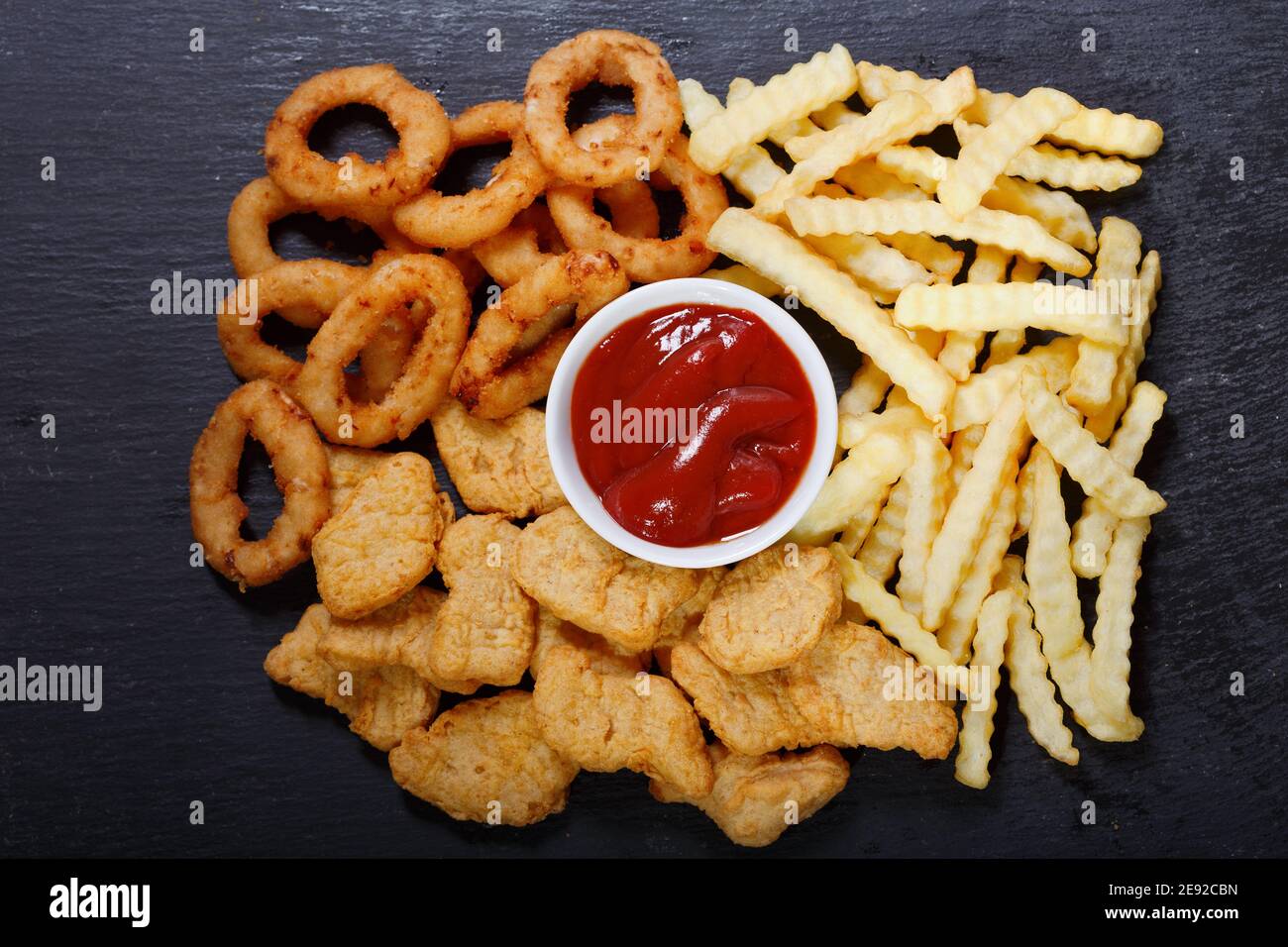 fast food products: onion rings, french fries and chicken nuggets on ...