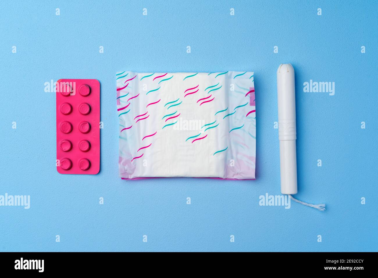 Contraceptive pills, hygienic pads and tampons on blue background Stock ...