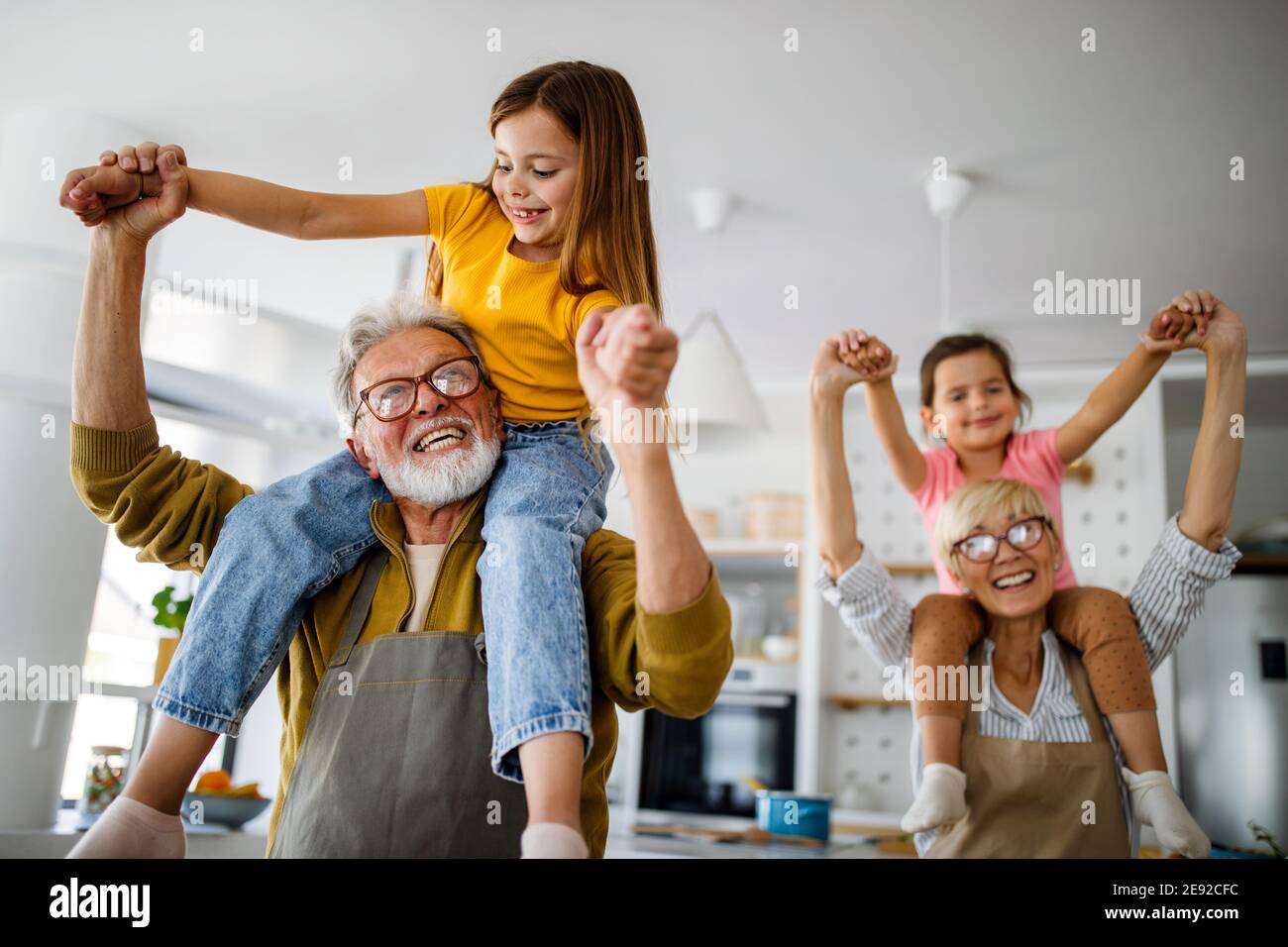 Grandchildren having fun at home while playing with their grandparents ...