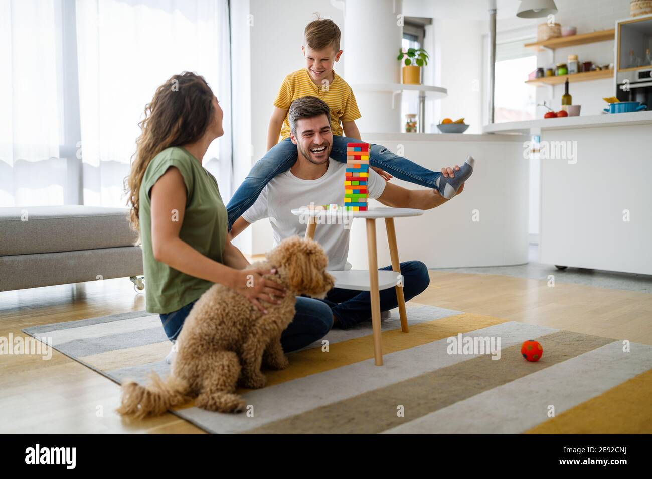 Happy family playing, having fun with dog at home Stock Photo - Alamy