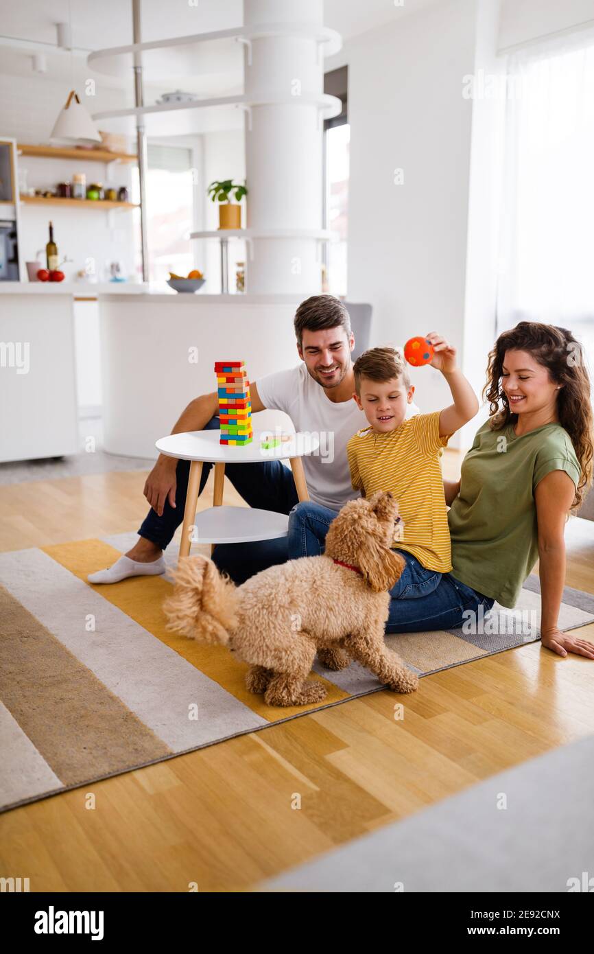 Happy family playing, having fun with dog at home Stock Photo - Alamy