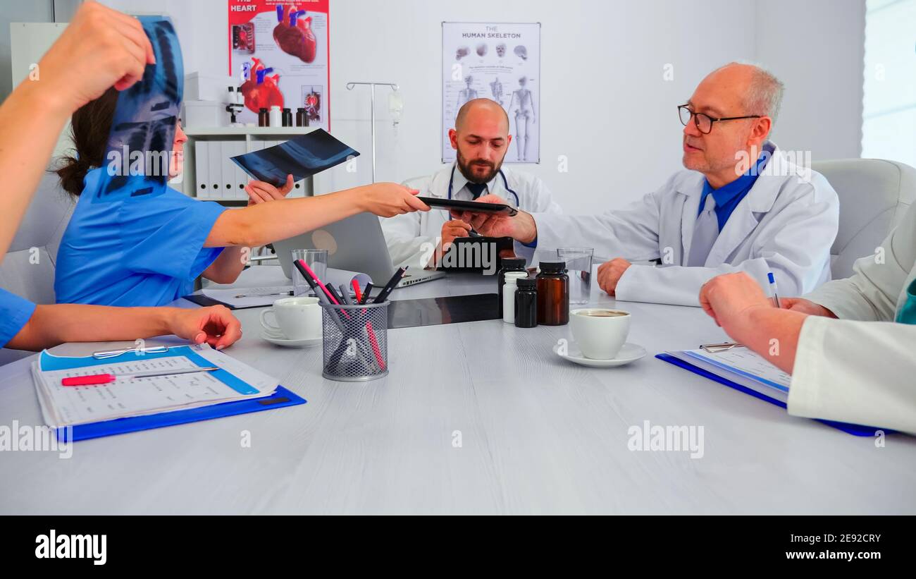 Group of medical staff discussing in hospital meeting room about ...