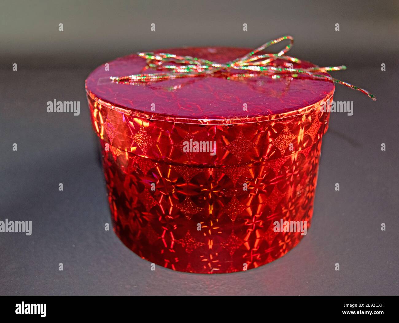 Round and red closed gift box isolated on grey background for special ...
