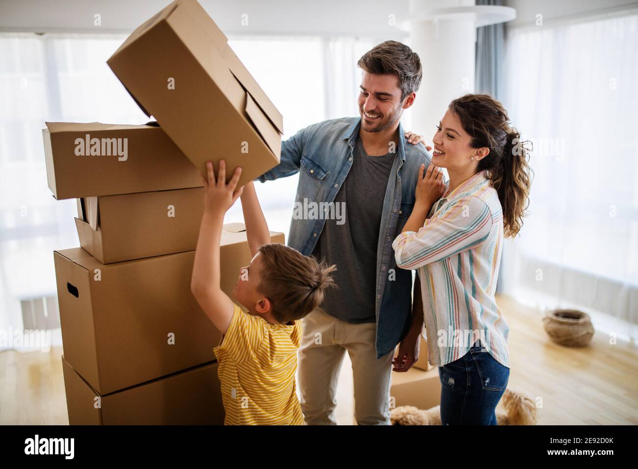 Family unpacking cardboard boxes at new home Stock Photo - Alamy