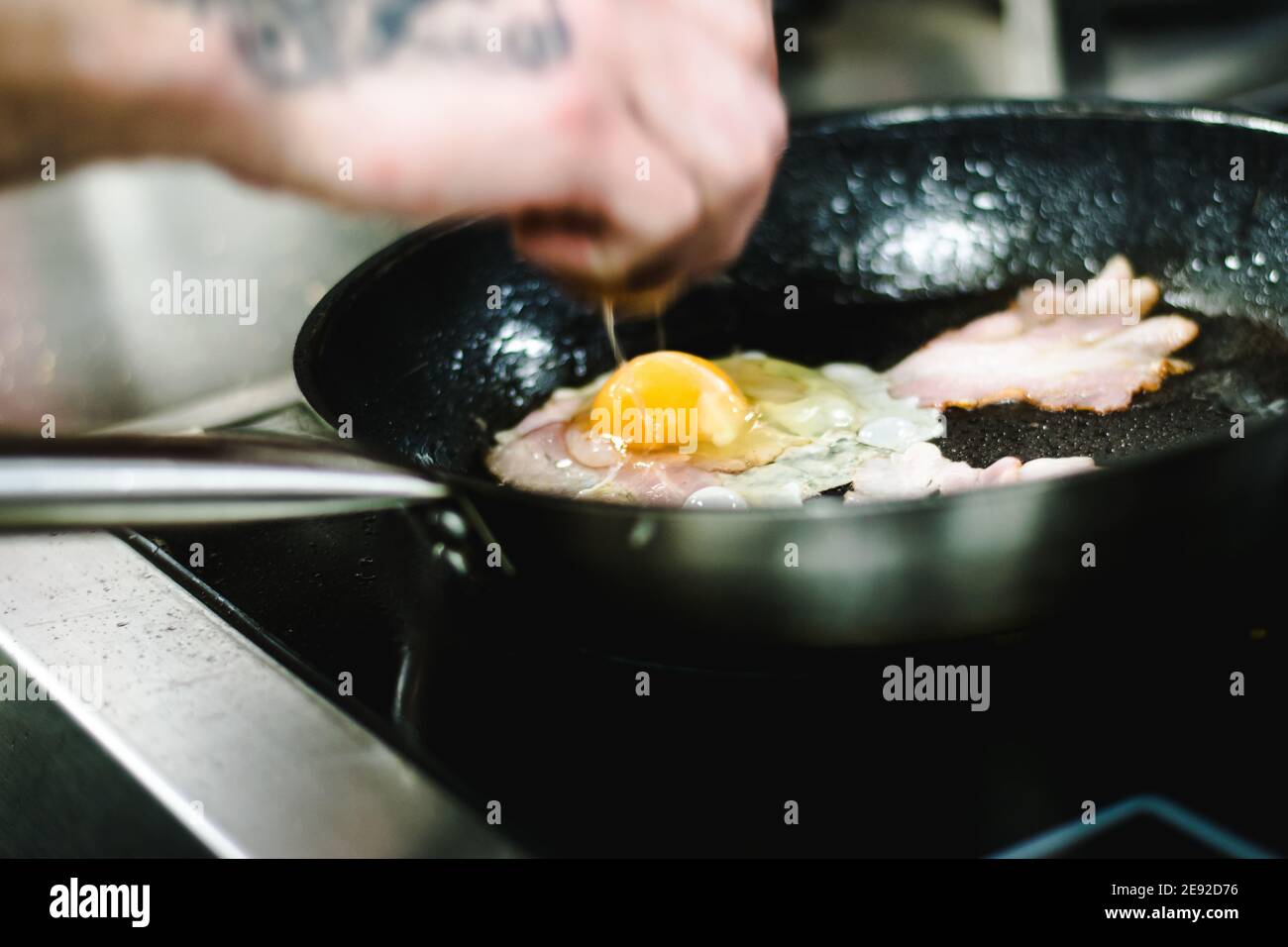 Chef preparing breakfast with eggs and bacon at a restaurant Stock ...