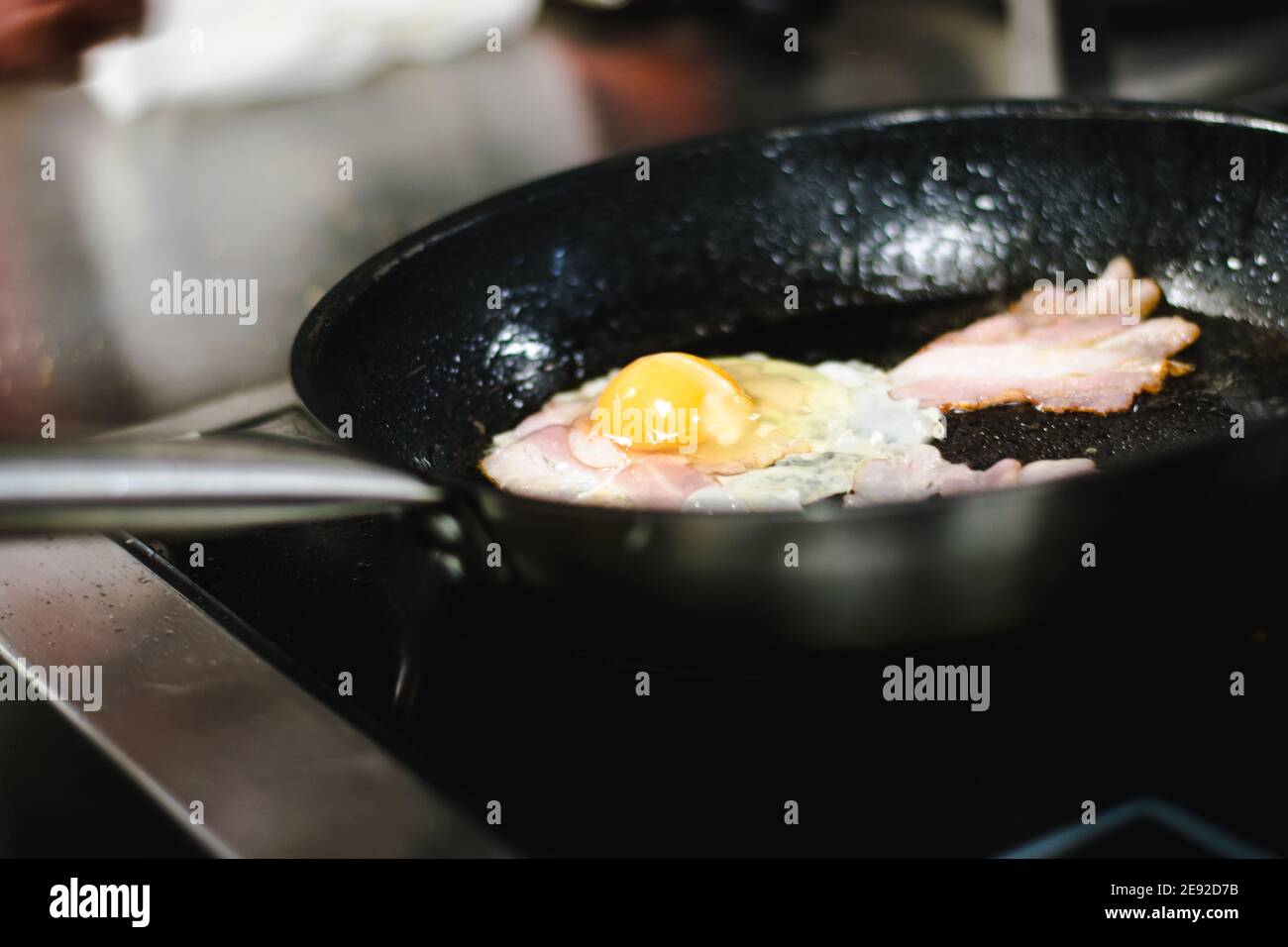 Chef preparing breakfast with eggs and bacon at a restaurant Stock ...