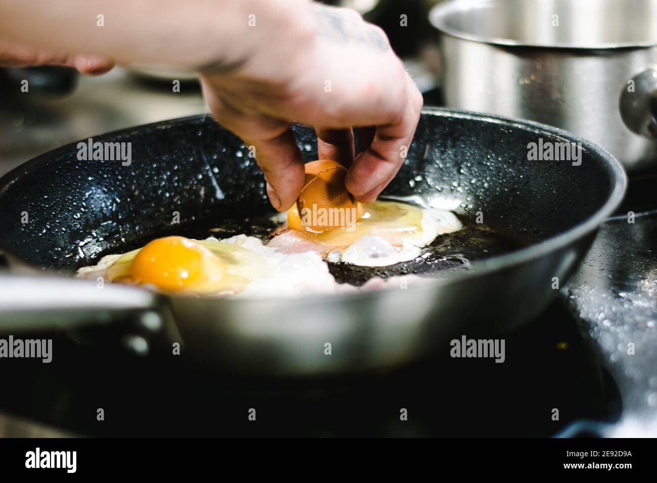 Chef preparing breakfast with eggs and bacon at a restaurant Stock ...