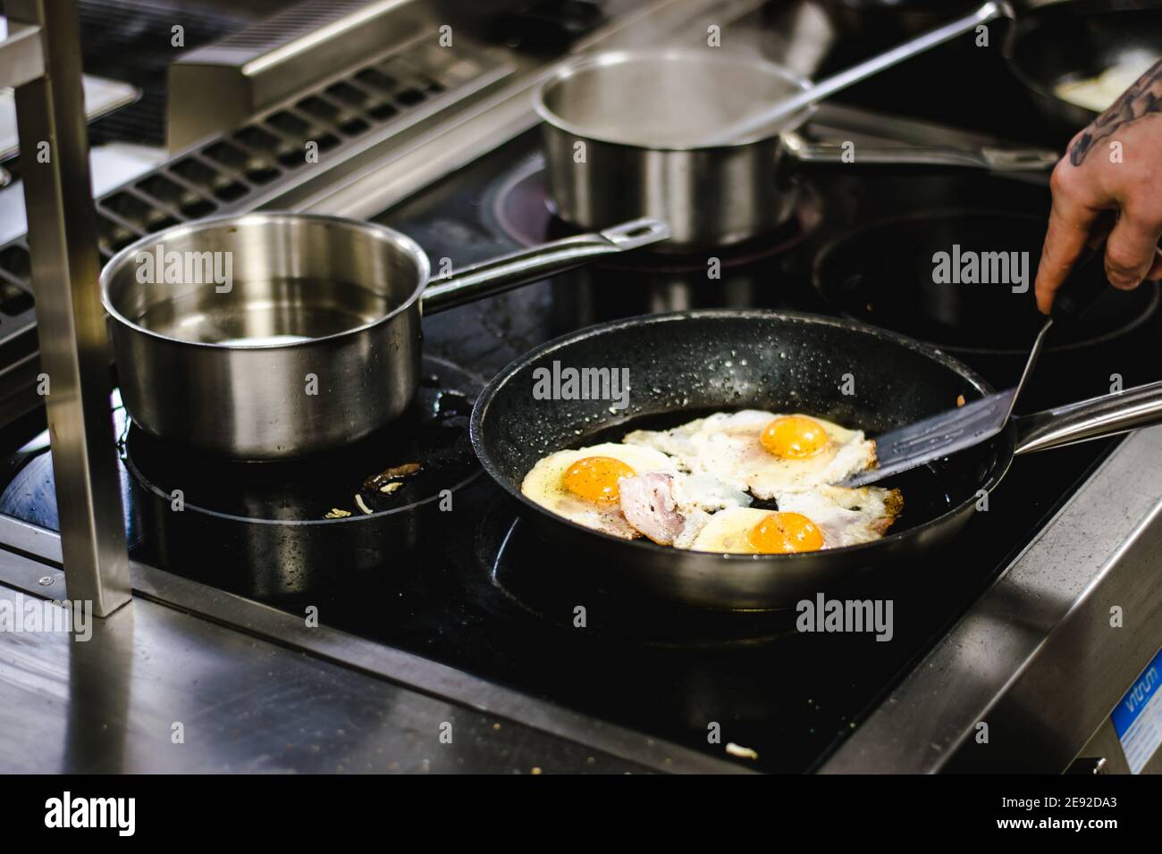 Chef preparing breakfast with eggs and bacon at a restaurant Stock ...