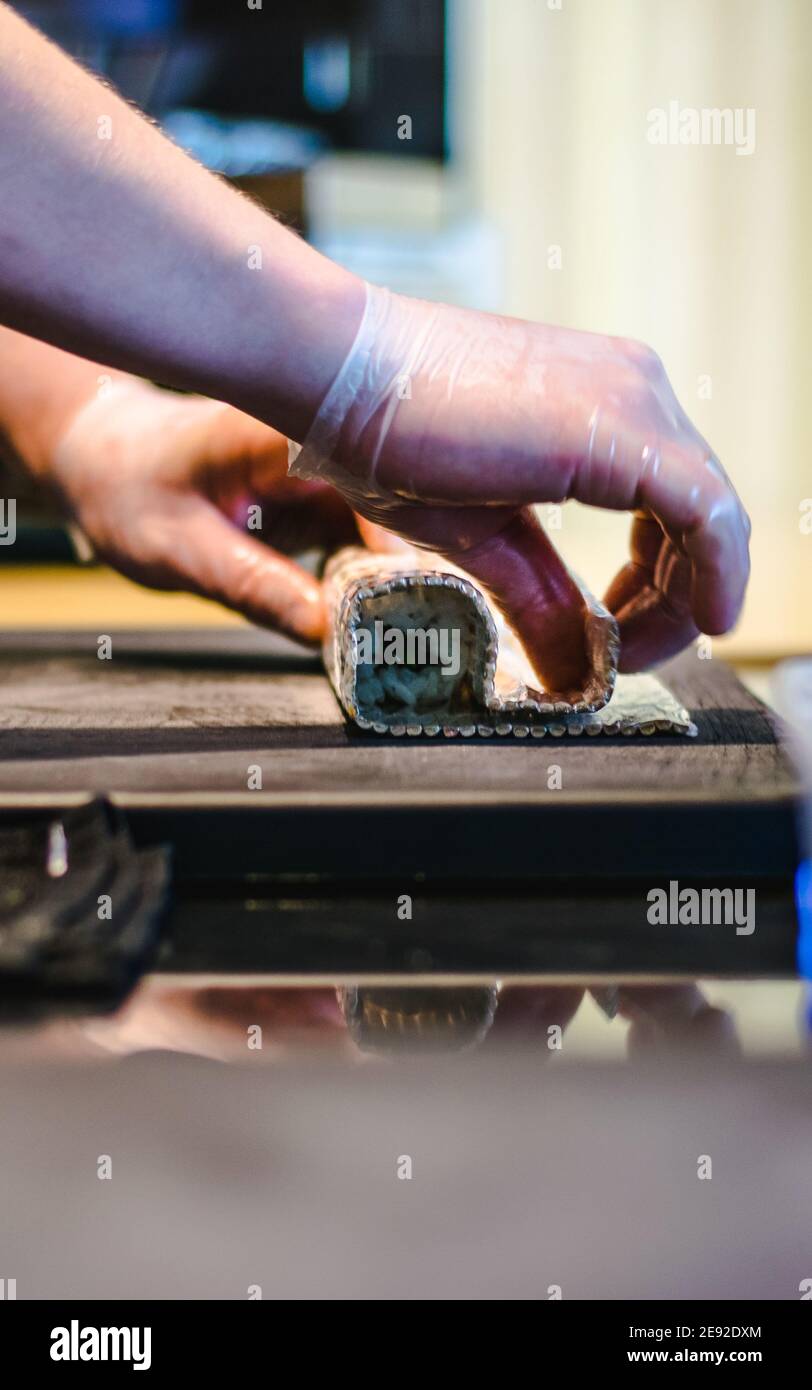 Sushi chef making maki and sashimi sushi at a sushi restaurant Stock ...