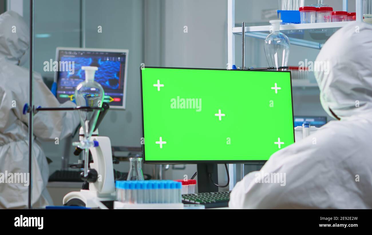Man researcher in coverall looking at chroma key computer in modern ...