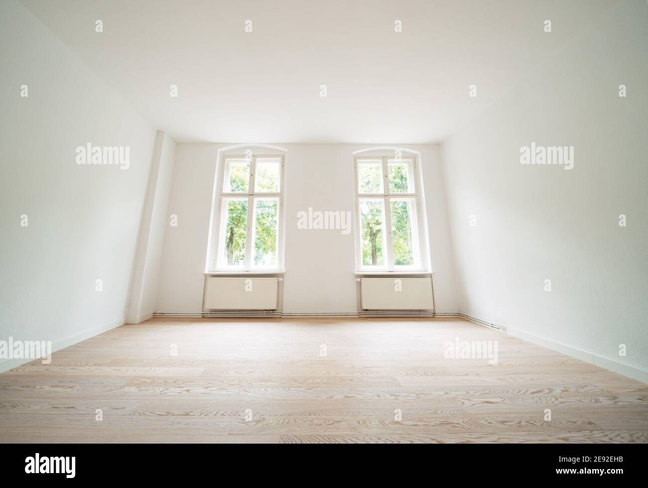 an empty room in an apartment with two windows Stock Photo - Alamy