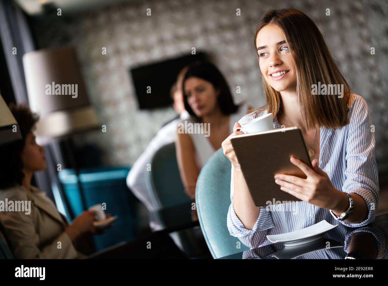 Happy young woman drinking tea and using tablet computer Stock Photo ...