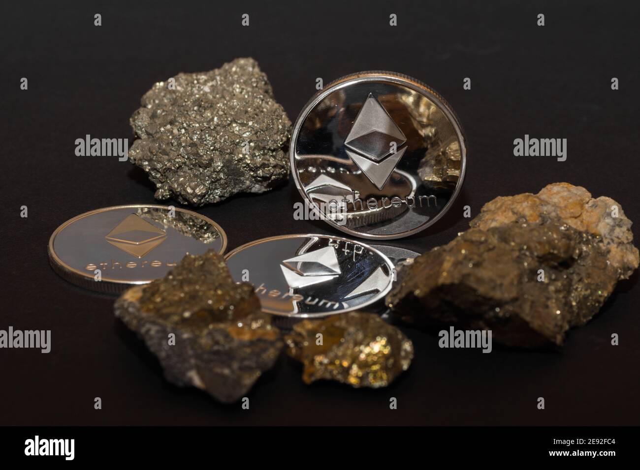 three silver shining ether coins from cryptocurrency and minerals with ...