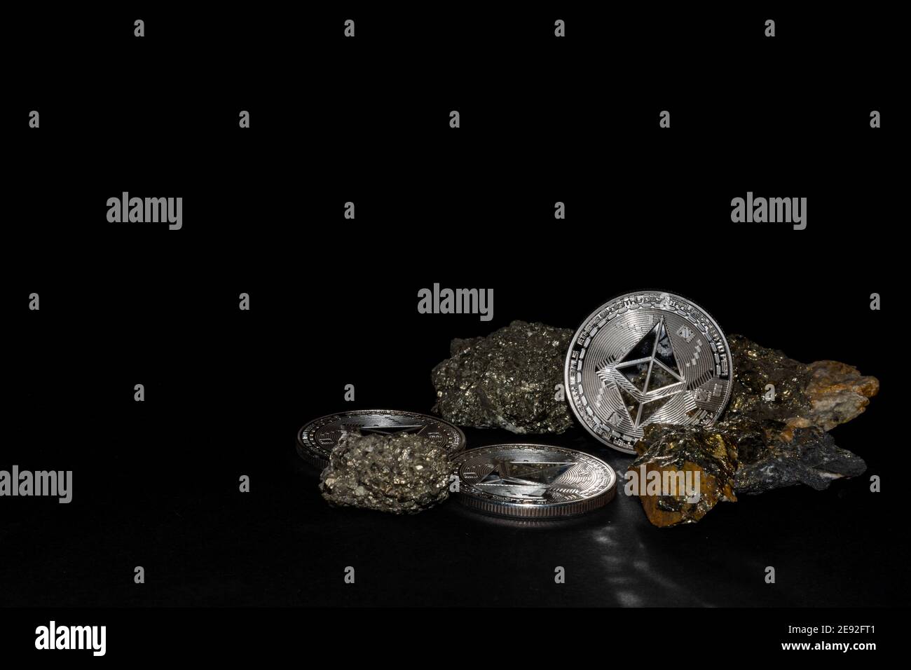 silver ether coins from ethereum currency and minerals bottom on black ...