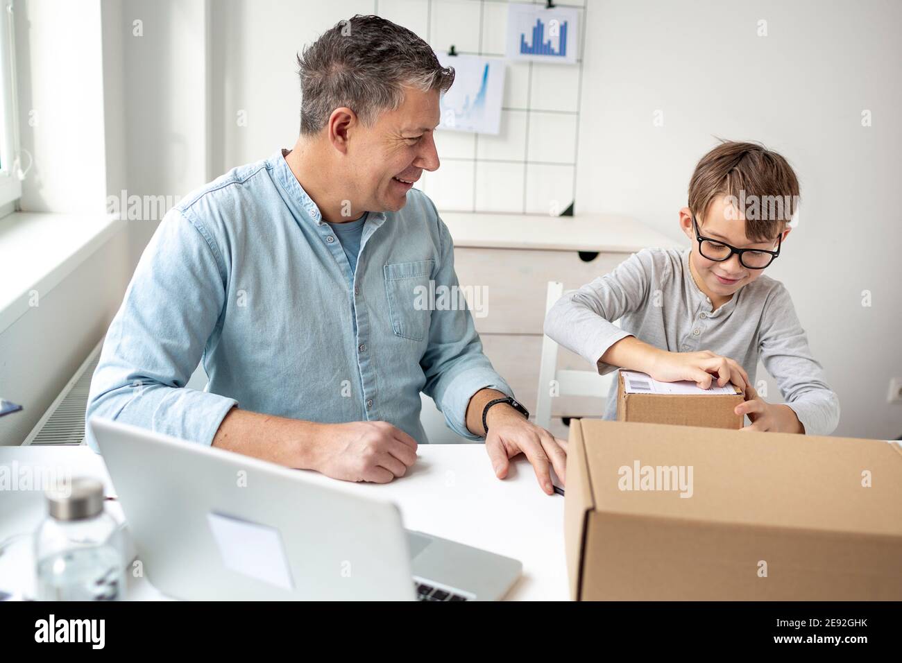 Online shopping concept. Father and son open a package from an online ...